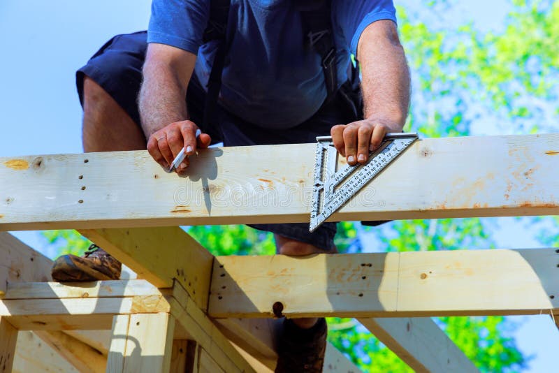 Skilled Carpenter Measures Wood for Construction on a Sunny Day at a ...