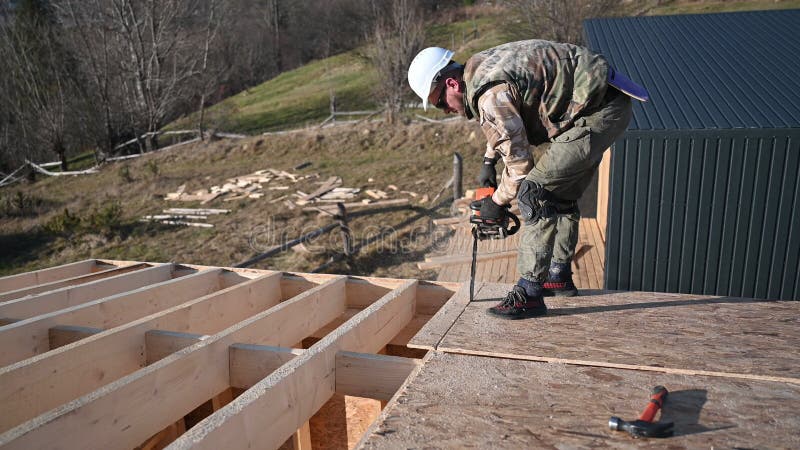 Carpenter Using Chainsaw for Cutting OSB Board for Building Wooden ...