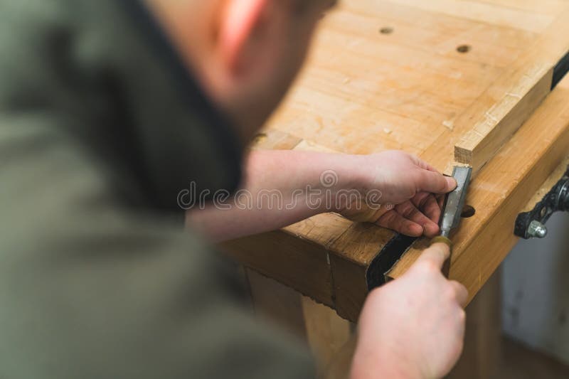 Carpenter Using a Chisel and Carving a Piece of Wood in the Workshop ...