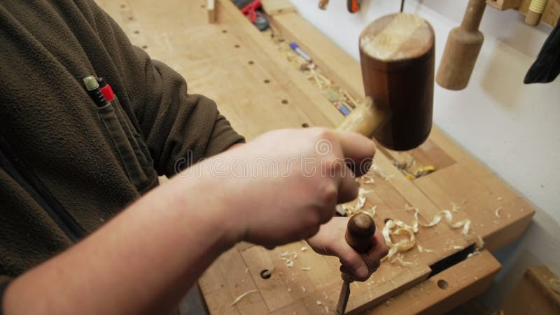 Carpenter Using a Chisel and a Hammer To Carve Wood on a Carpentry ...