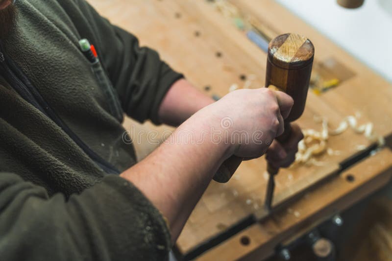 Carpenter Using a Chisel and a Hammer To Carve Wood on a Carpentry ...