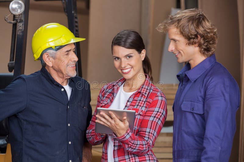 Carpenter Using Digital Tablet with Coworkers Stock Image - Image of ...