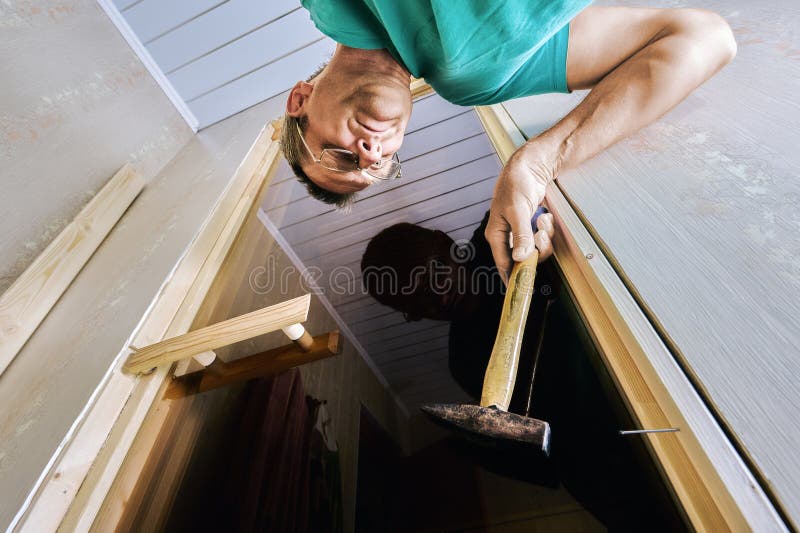 Carpenter Using Hammer To Secure Jamb To Door Frame, Beginning with ...