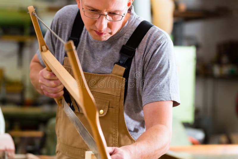 Carpenter using hand saw stock image. Image of occupation - 92679967
