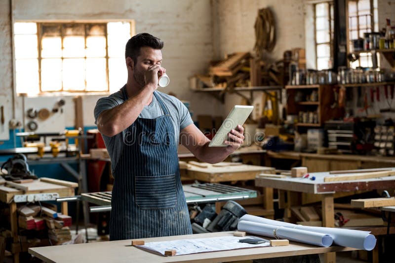 Carpenter Using His Tablet and Drinking a Coffee Stock Image - Image of ...