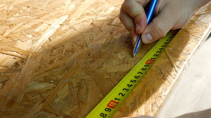 Carpenter Using Measuring Tape To Mark Section of Plywood Stock Photo ...