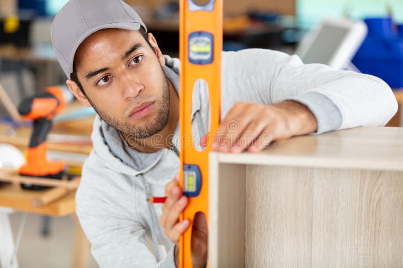Carpenter Using Spirit Level for Leveling Assembled Furniture Stock ...