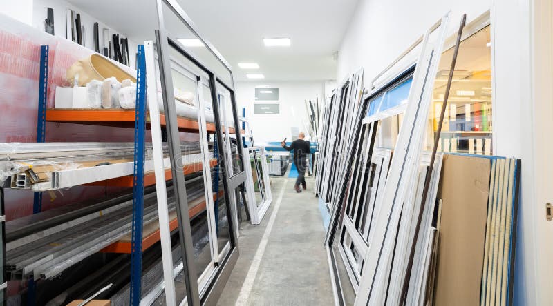 Carpenter Walking in Workshop with Aluminum Window Frames and Shelving ...