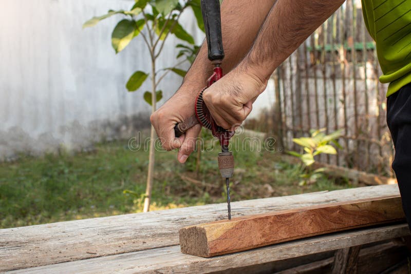 A Carpenter is Using an Antique Drill To Drill Wood To Repair a Broken ...