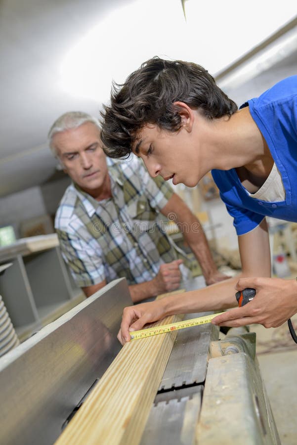 Carpenter Watching Apprentice Work Stock Image - Image of industrial ...
