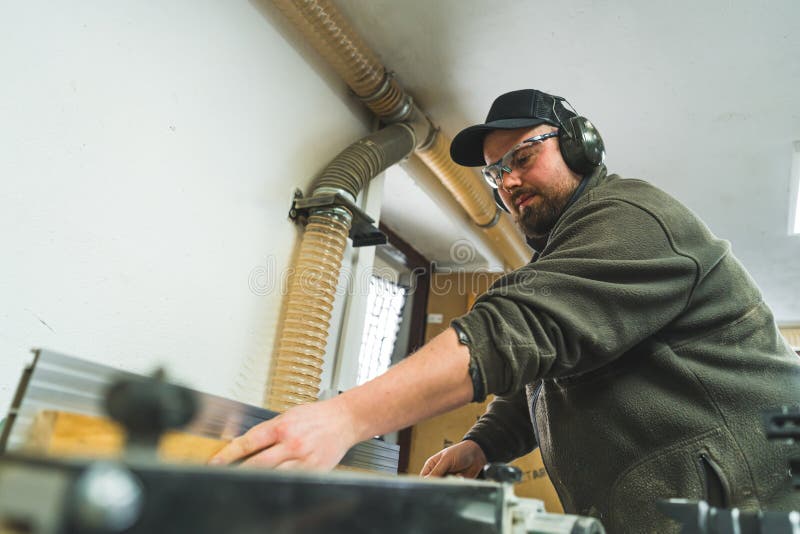 Carpenter during Work. Focused Male Woodworking Craftsman in Protective ...