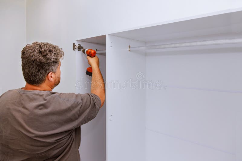Carpenter Working on Assembling Furniture Closet Cabinets that Needed ...