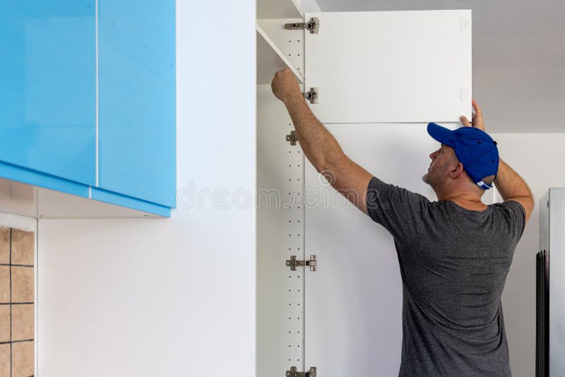 Carpenter Working on New Kitchen. Handyman Fixing a Door in a Kitchen ...