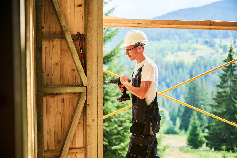 Carpenter Working with Screwdriver while Constructing Wooden Framed ...