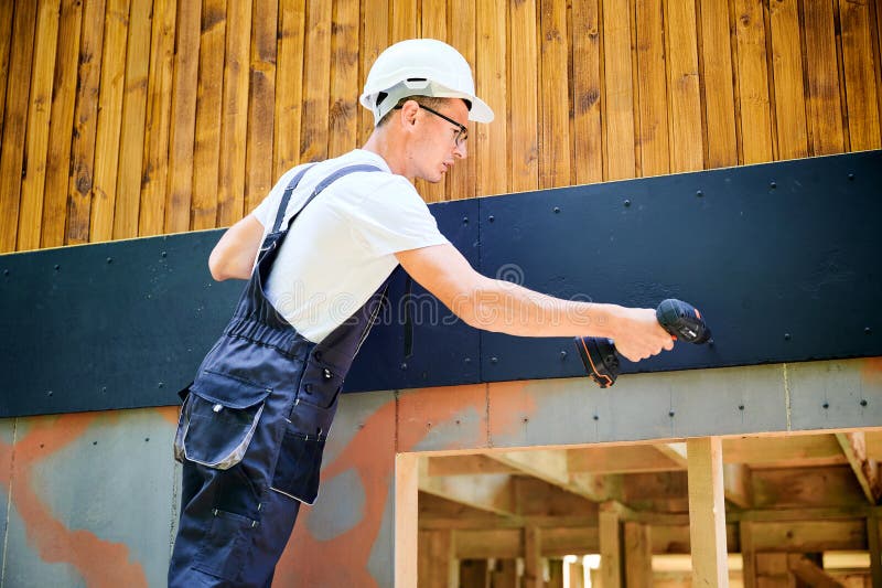 Carpenter Working with Screwdriver while Constructing Wooden Framed ...