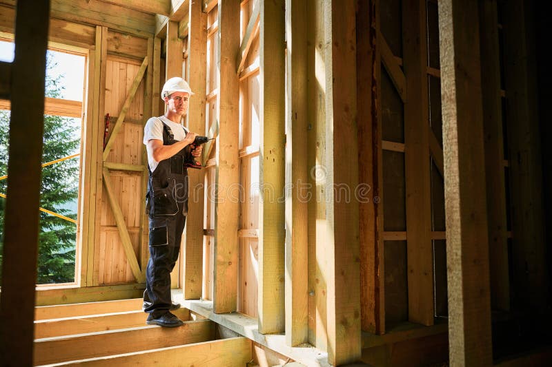 Carpenter Working with Screwdriver while Constructing Wooden Framed ...