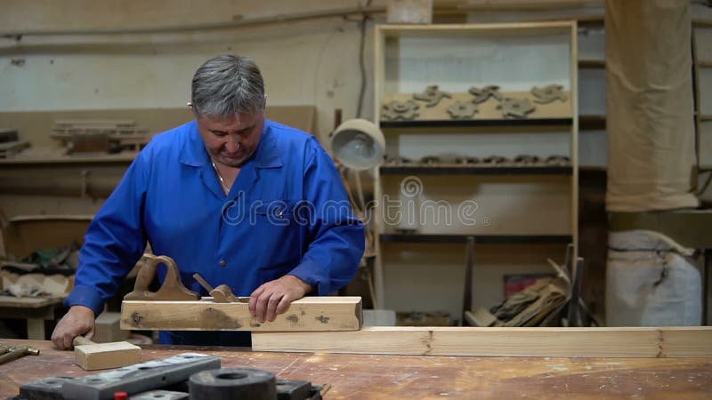 Carpenter Working in the Studio, Worker Planing a Tree with a Planer ...