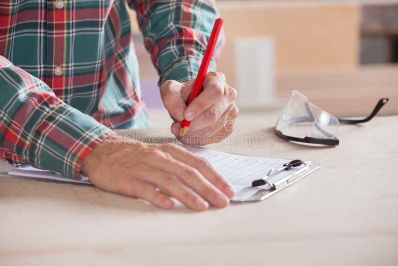 Carpenter Writing Notes on Clipboard at Table Stock Image - Image of ...