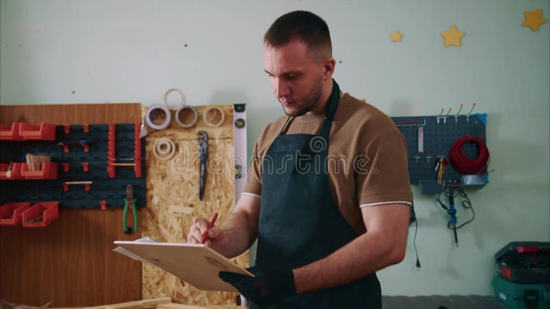 Carpenter Writing Notes on Clipboard in Workshop Stock Video - Video of ...