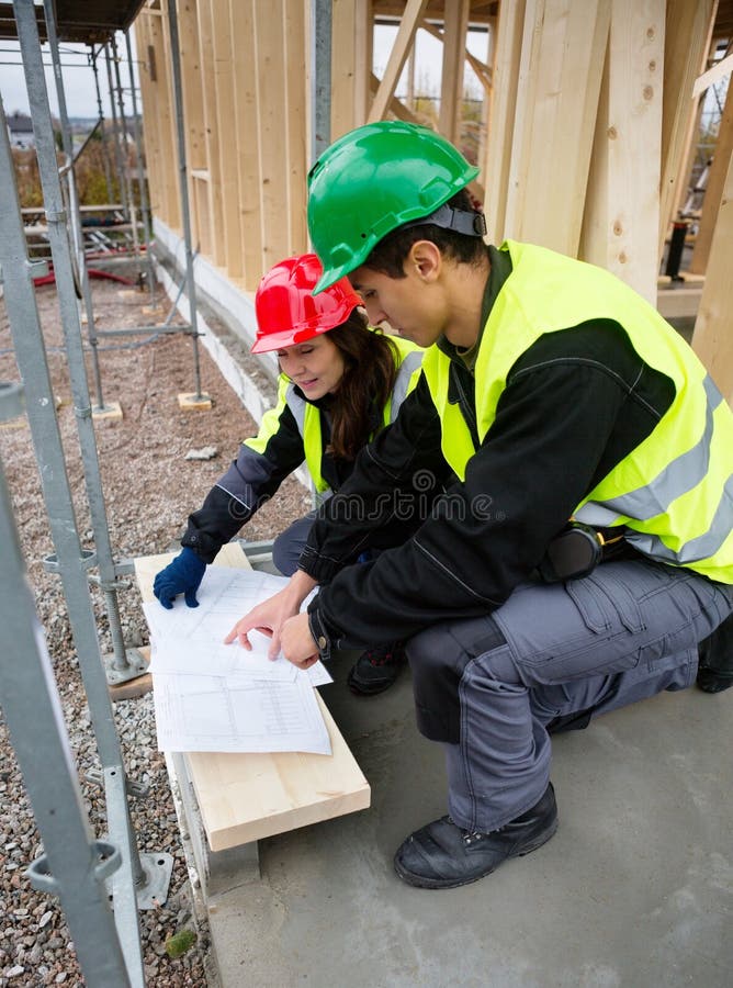 Carpenters Discussing Over Plan at Construction Site Stock Photo ...
