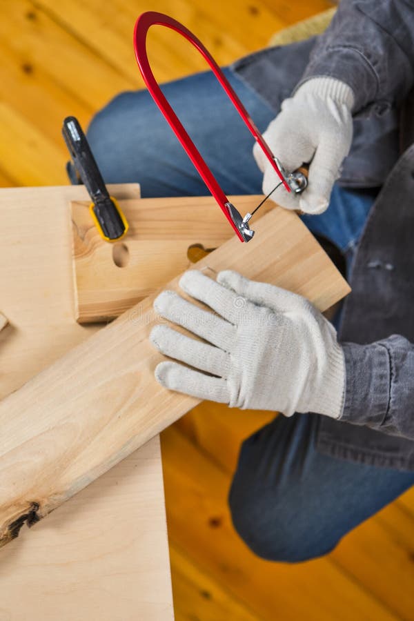 Carpentry Ideas. Hands of Carpenter in Apron Working with Fret-Saw and ...
