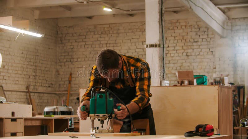 Carpentry Industry - Man Worker Starts Working with a Grinding Machine ...