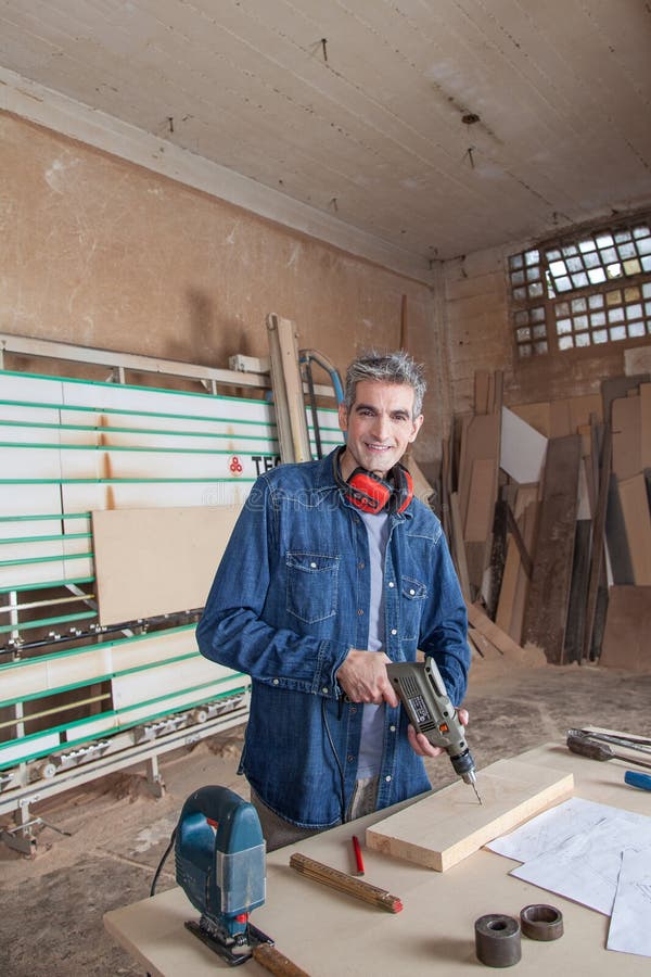 Carpintero En Su Escritorio Con Un Taladro Foto de archivo - Imagen de ...