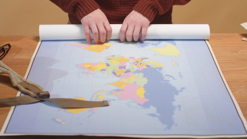 A Man Rolls a Map and Takes Out Paper and Pen Stock Photo - Image of ...