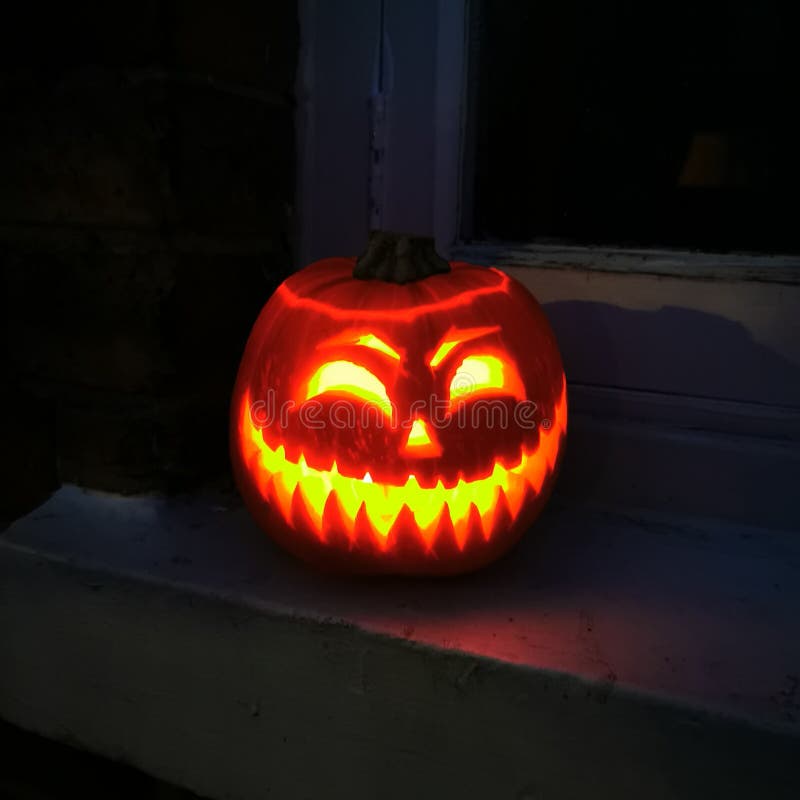 Carved Pumpkin Glowing at Night Stock Image - Image of night, sill ...