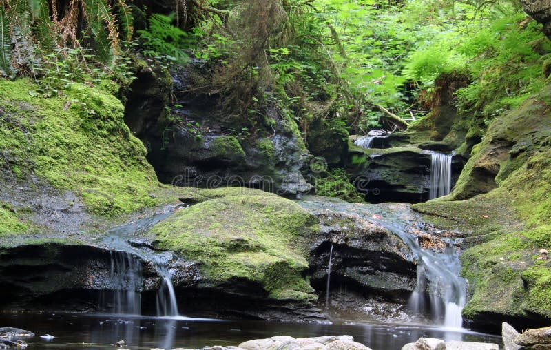 A Waterfall Cascading Down the Side of a Mountain Stock Photo - Image ...