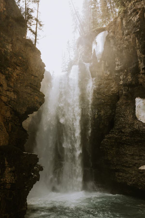 Cascading Waterfall Surrounded by Towering Rocky Cliffs Stock Photo ...