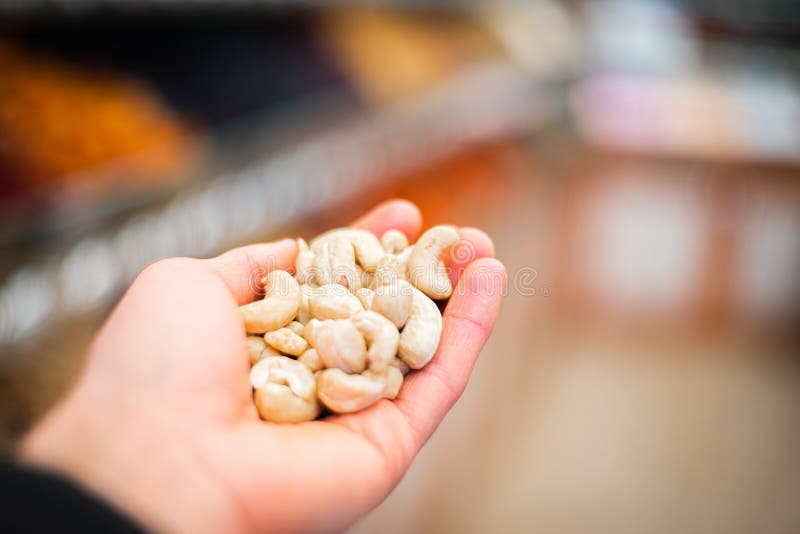 Cashew nuts in hands stock photo. Image of closeup, bean - 254143740