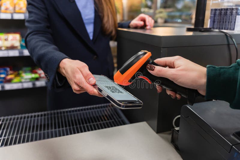 A Cashier Scans a Qr Code from a Smart Phone Using a Barcode Scanner ...
