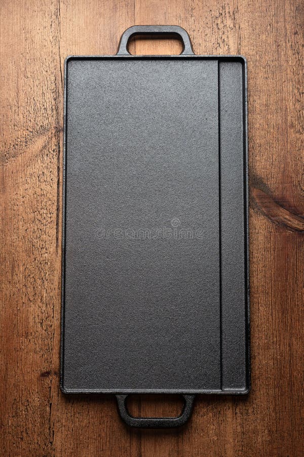 Cast Iron Grill Griddle Plate Pan on Rustic Wooden Table Stock Photo ...