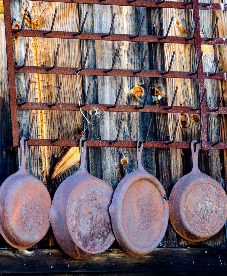 Cast Iron Skillets on a Rusty Rack Stock Image - Image of pans, iron ...