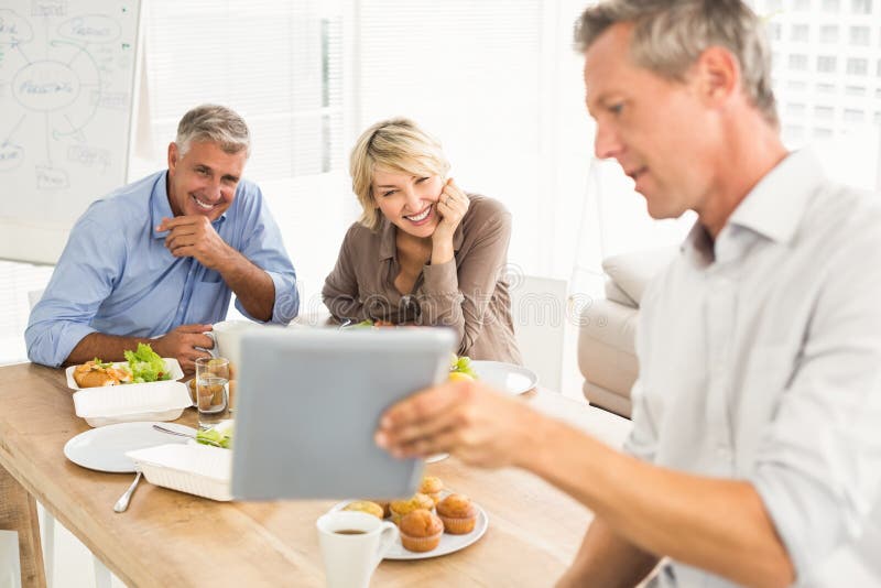 Casual Business People Looking at Tablet while Lunch Stock Photo ...