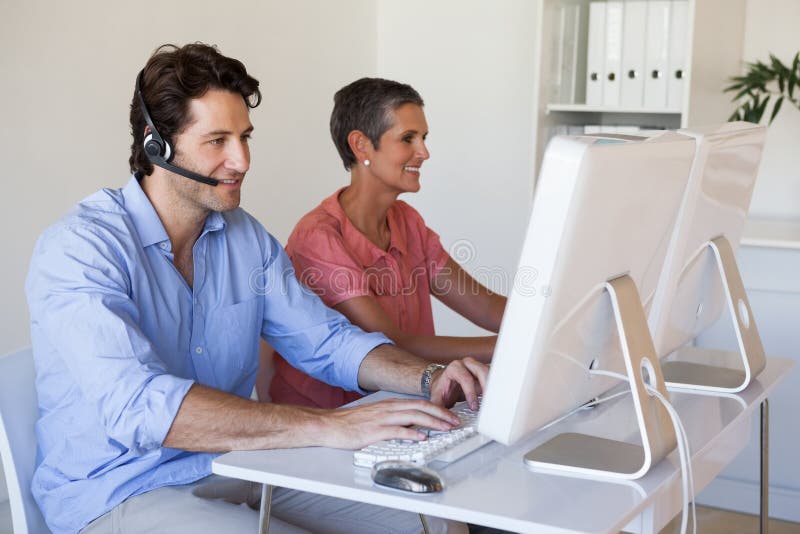Casual Business Team Working at Desk Using Computers with Man Using ...