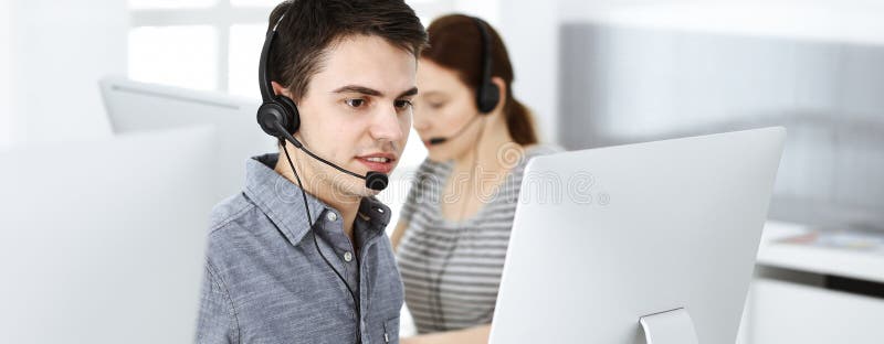 Casual Dressed Young Man Using Headset and Computer while Talking with ...