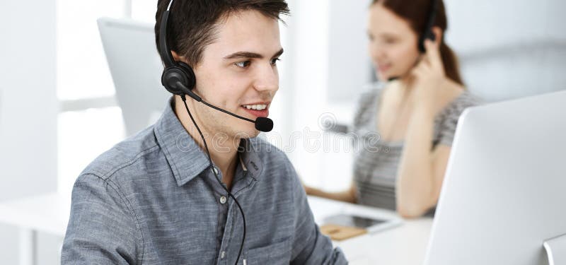 Casual Dressed Young Man Using Headset and Computer while Talking with ...