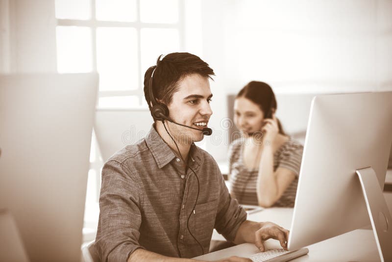 Casual Dressed Young Man Using Headset and Computer while Talking with ...