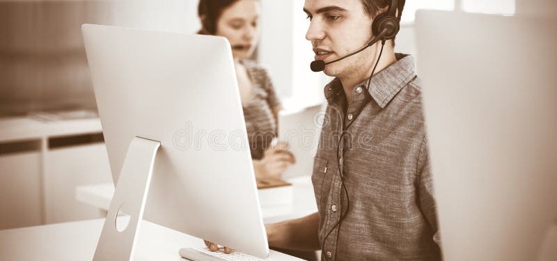 Casual Dressed Young Man Using Headset and Computer while Talking with ...