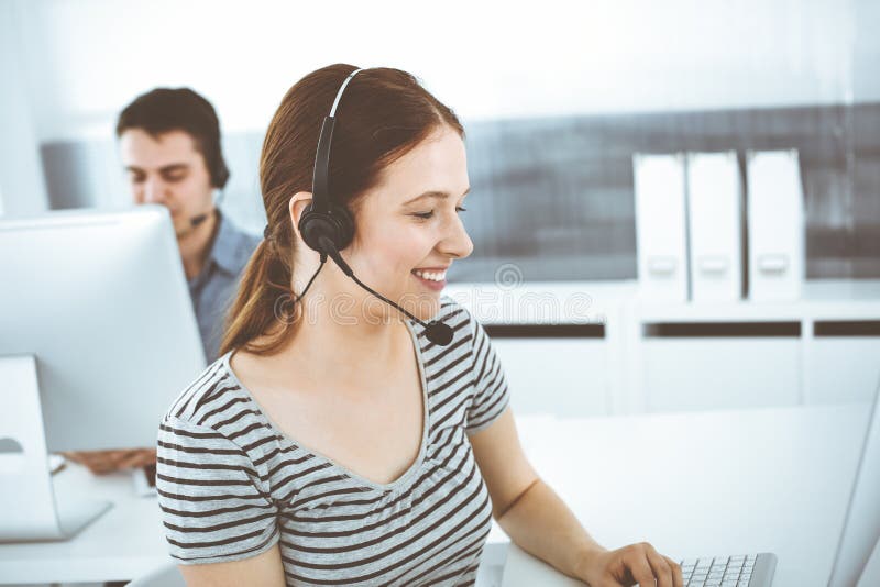 Casual Dressed Young Woman Using Headset and Computer while Talking ...