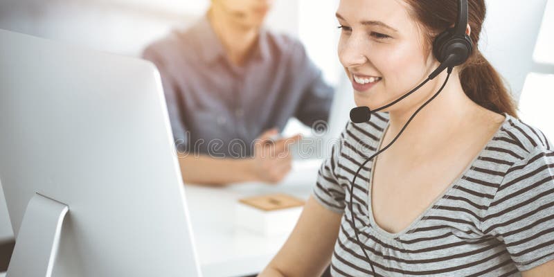 Casual Dressed Young Woman Using Headset and Computer while Talking ...