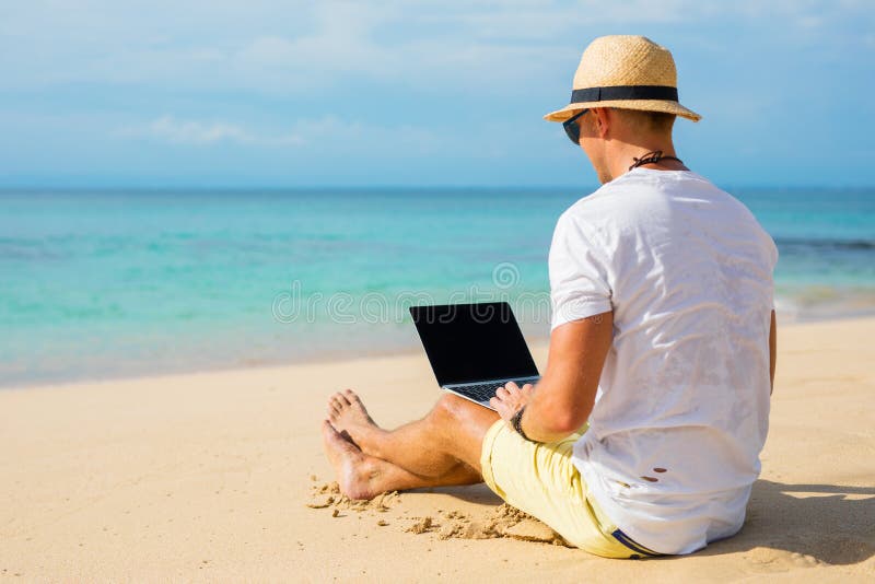Casual Looking Guy Using Laptop on the Beach Stock Photo - Image of ...