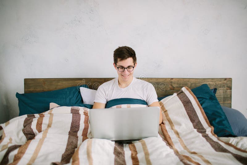 Casual Young Man Using Laptop in Bed at Home Stock Image - Image of ...