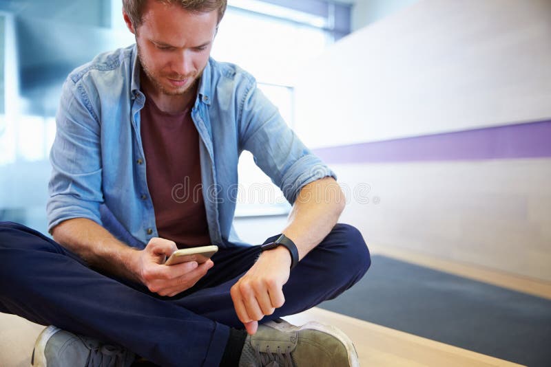 Casually Dressed Man with Smart Phone, Looking at His Watch Stock Photo ...