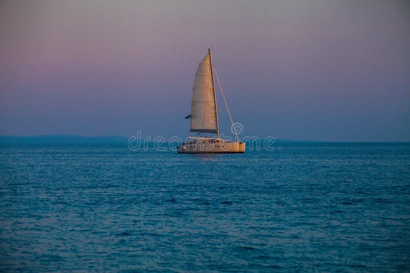 Catamaran yacht at sunset stock image. Image of summer - 135649471