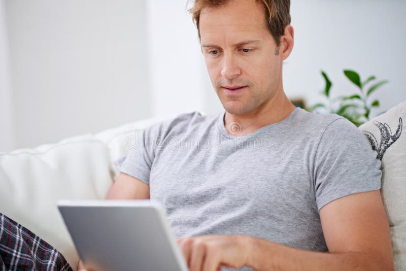 Catching Up on His Emails. a Handsome Man Using His Tablet at Home ...