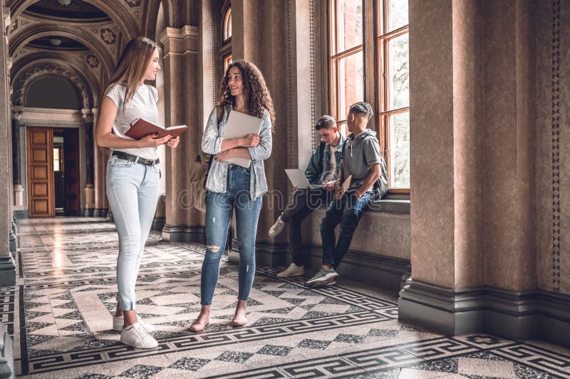 Catching Up before the Next Class.Group of Confident Students Standing ...