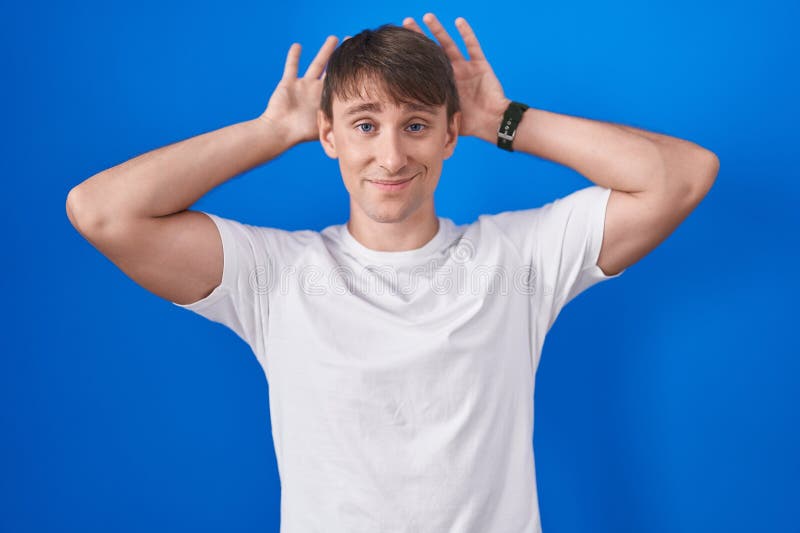 Caucasian Blond Man Standing Over Blue Background Doing Bunny Ears ...